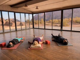 Um quarto espaçoso com grandes janelas que oferecem vista para uma paisagem desértica.