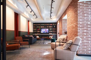Uma sala de estar moderna com parede de tijolos, lareira e estante de livros.