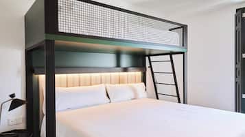 Uma cama beliche com escada, roupa de cama branca e luminária fixada na parede.
