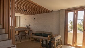 Uma sala de estar moderna com sofá, cadeiras, mesa de centro e um espaço de jantar com mesa e cadeiras.