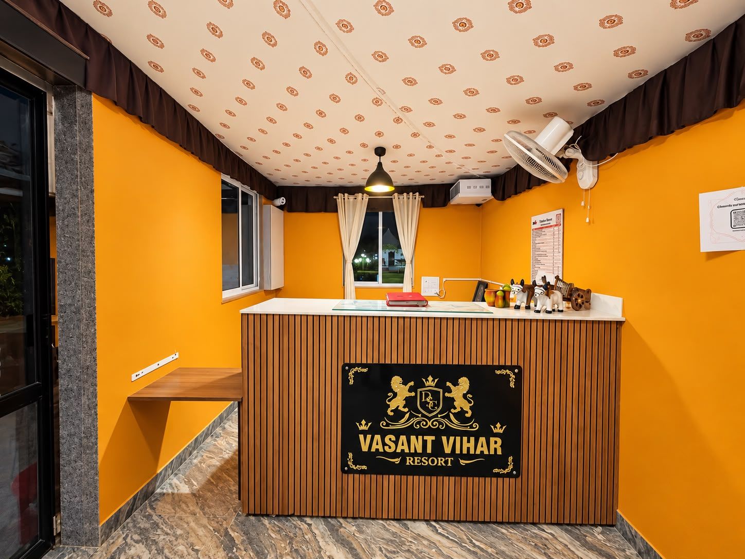 Uma receção com uma placa a indicar 'Vasant Vihar Resort'.