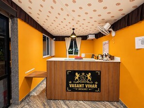 Uma receção com uma placa a indicar 'Vasant Vihar Resort'.