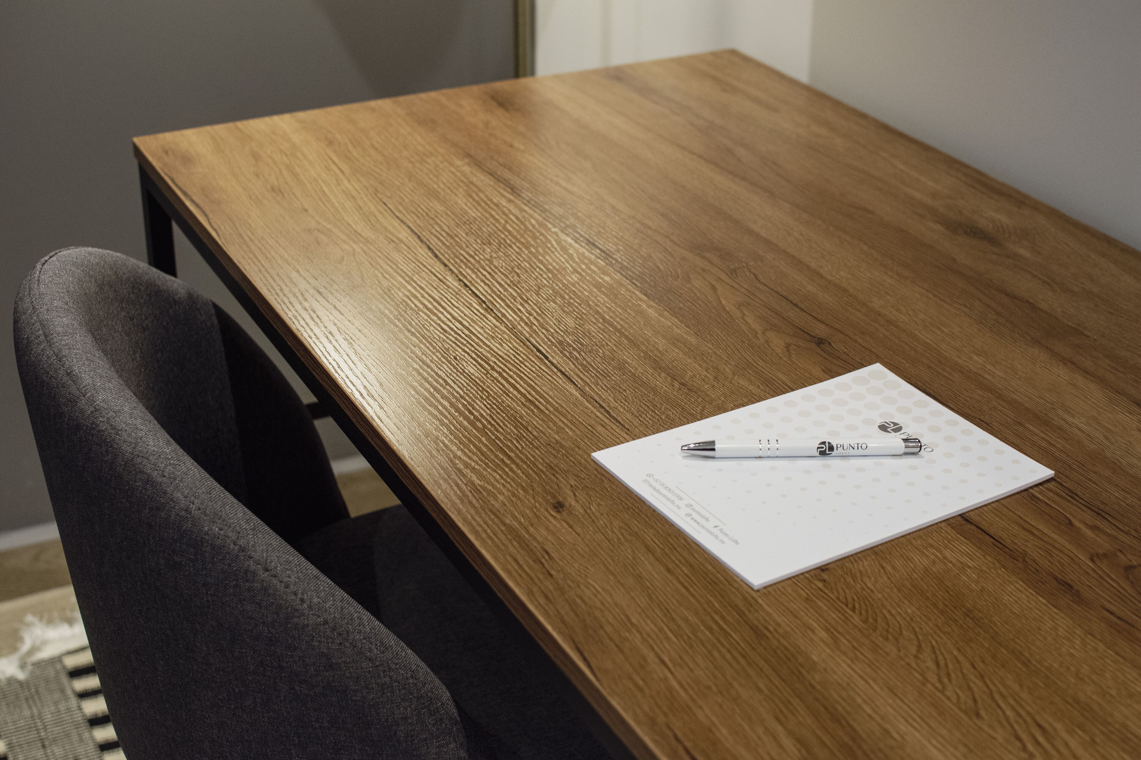 Uma mesa de madeira com caneta e papel.