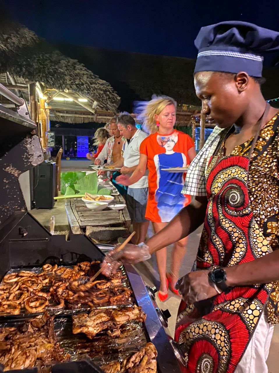Alguém assando comida ao ar livre à noite.