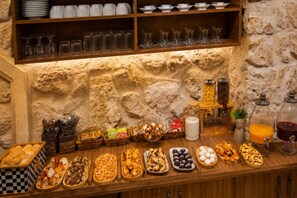 Um buffet com diversos alimentos, copos e dosadores de temperos.