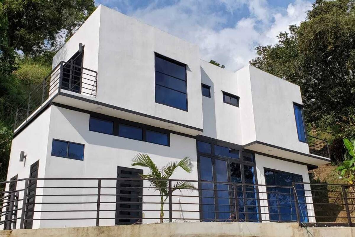 Um edifício moderno de dois andares, com janelas amplas e uma varanda.