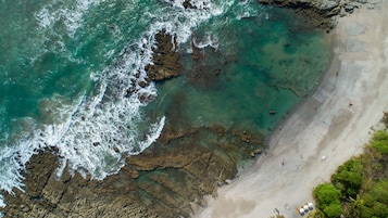 Uma praia com costa rochosa e águas cristalinas.