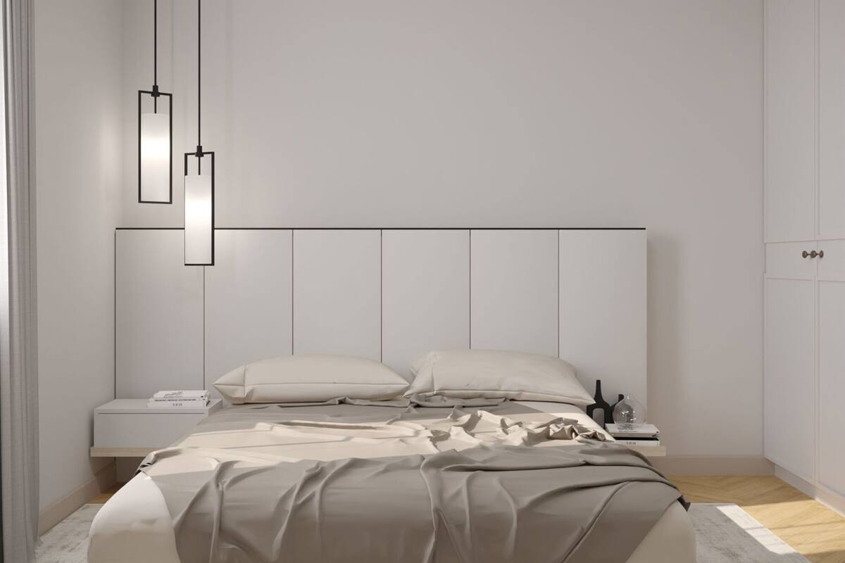 Um quarto moderno com cama, mesas de cabeceira e luminária pendente.