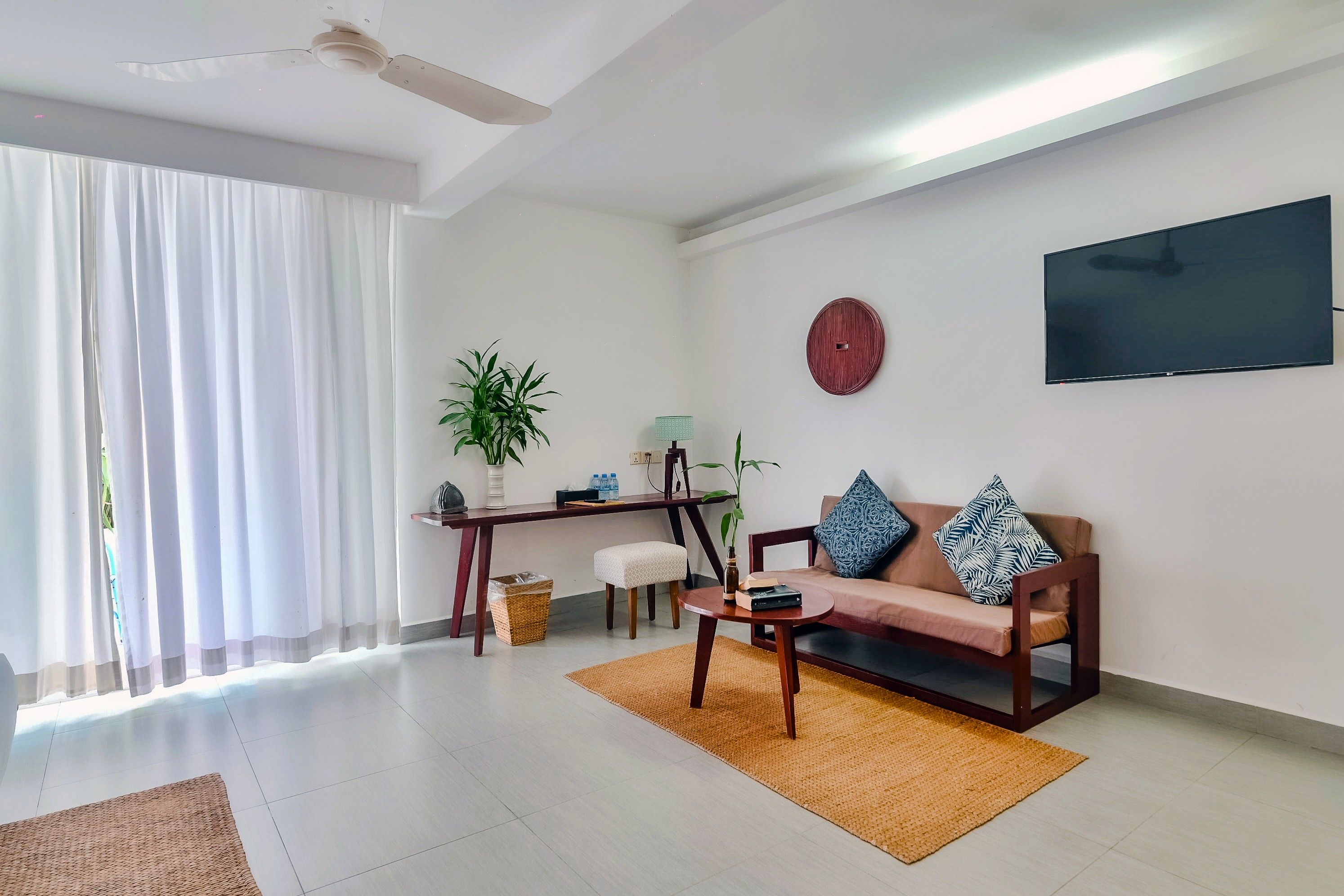 Uma sala de estar moderna com sofá, mesa de centro e TV fixada na parede.