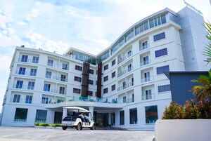 Um hotel de vários andares com design moderno, com entrada destacada e serviço de carrinho de golfe.