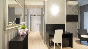 Quarto de hotel moderno com escrivaninha, cadeira e um espelho grande.