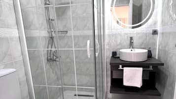 Um polibã, um chuveiro fixo, um secador de cabelo, roupões