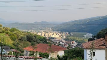 Um bairro residencial numa encosta, com casas, um rio e montanhas ao longe.