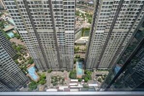 Um edifício residencial alto com pátio central, várias varandas e uma piscina.