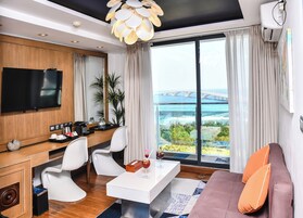 Suíte luxo, 1 cama de casal, vista para o oceano | Área de estar | TV LCD 35 polegadas com canais digitais