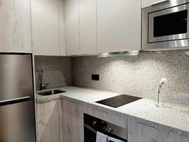 Um frigorífico, um micro-ondas, uma placa de cozinha 