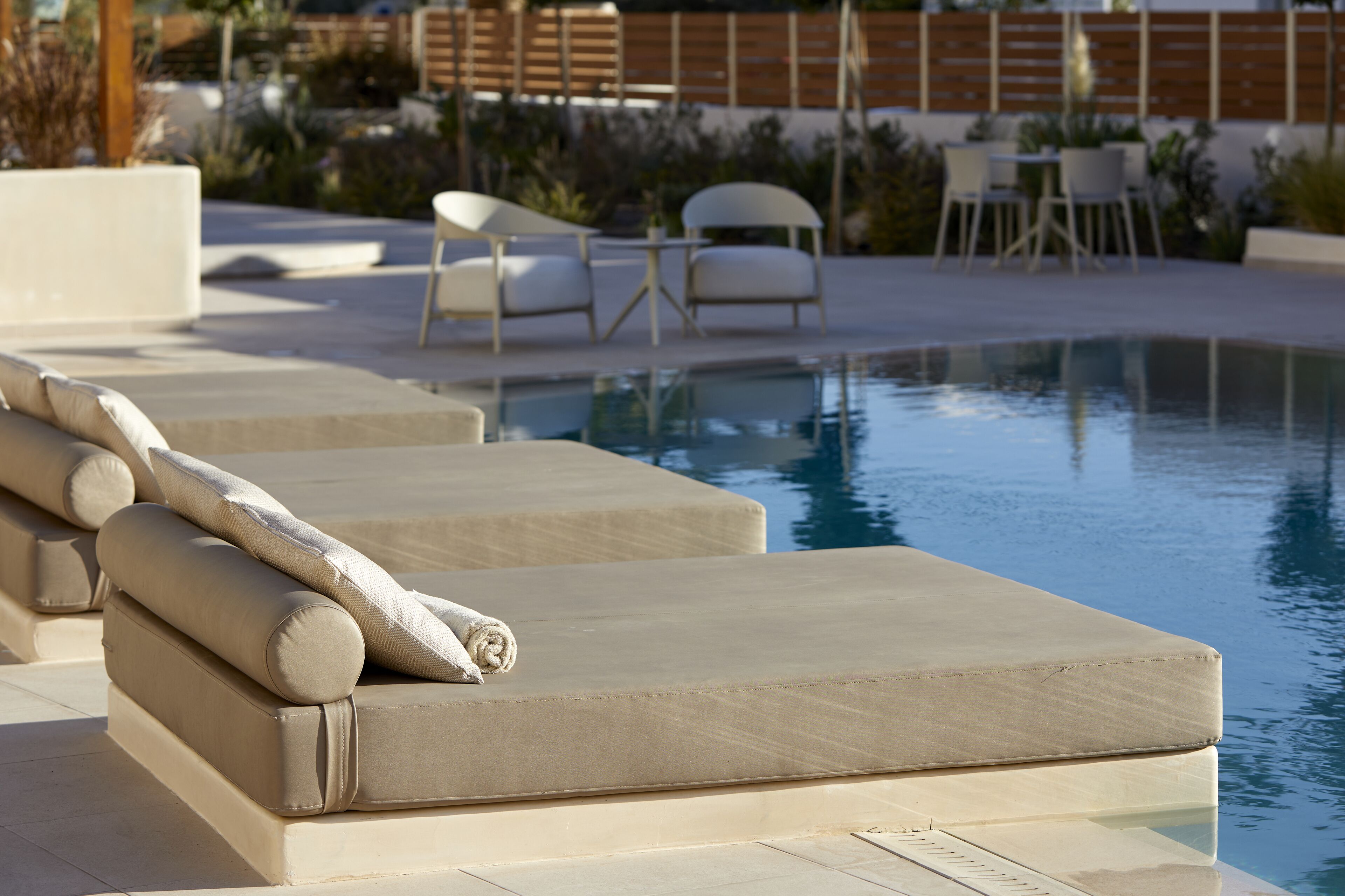 Uma área à beira da piscina com espreguiçadeiras e piscina.