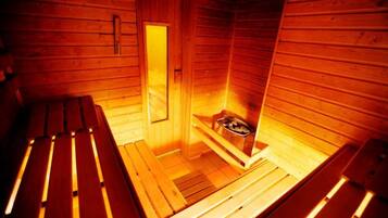 Uma sala de sauna com bancos de madeira e um elemento de aquecimento central.