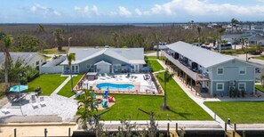 Zona residencial com piscina, várias casas e vista clara para o oceano.