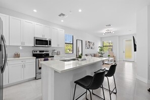 Um frigorífico/congelador grande, um micro-ondas, um forno 