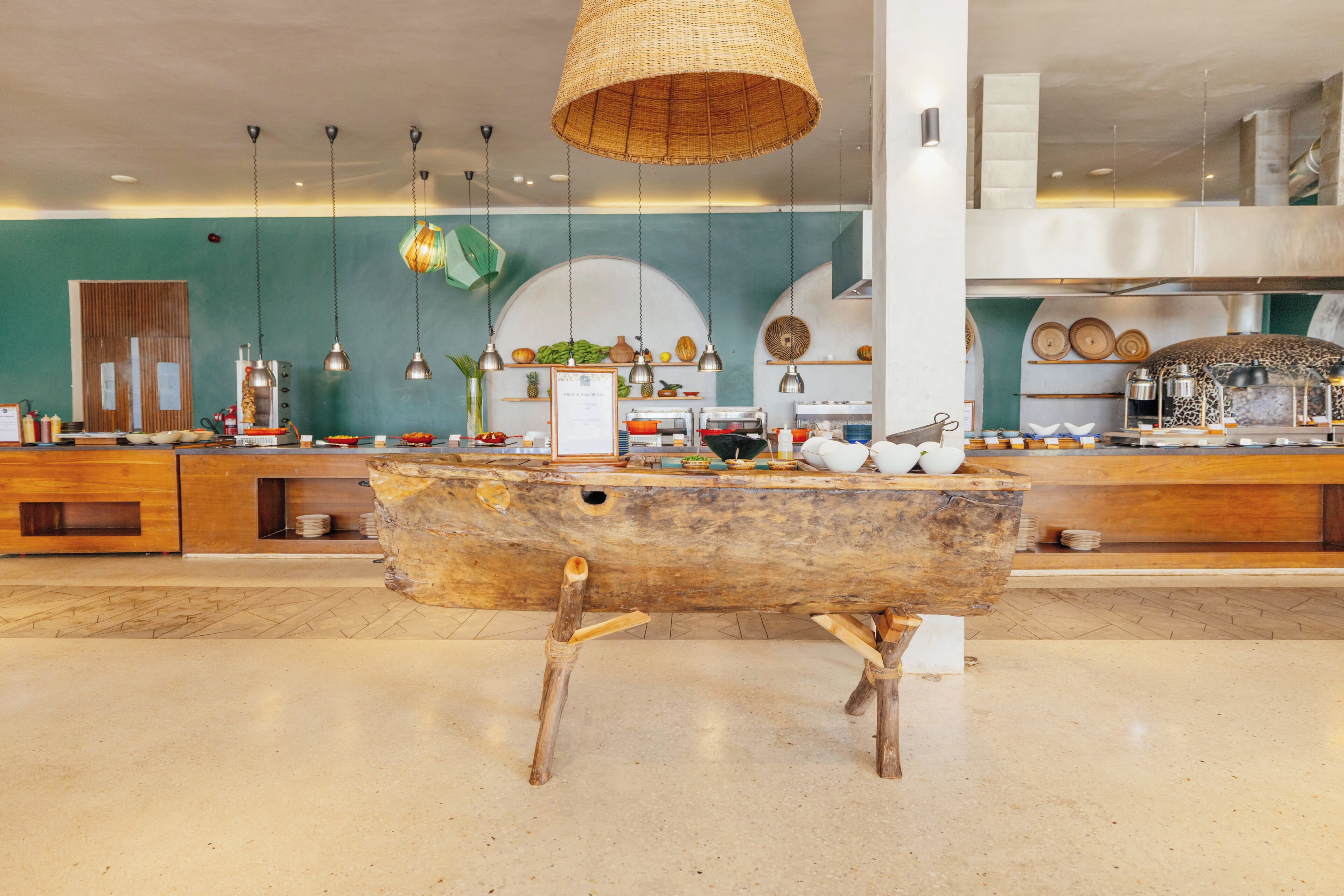 Uma mesa de madeira rústica com design exclusivo, rodeada por eletrodomésticos modernos e luminárias pendentes.