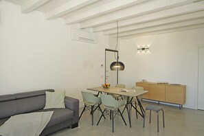 Um espaço moderno para viver, com área de refeições, sofá e armário de madeira.