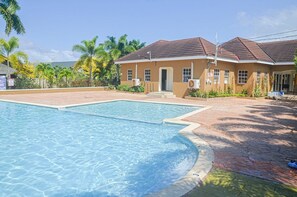Uma área de piscina com um edifício ao fundo.