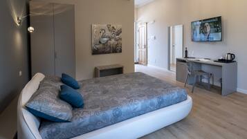 Quarto moderno com cama, escrivaninha e televisão.