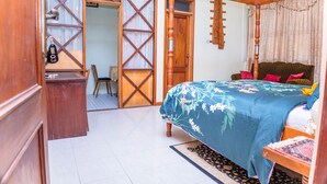 Quarto com cama, guarda-roupa de madeira e escrivaninha.
