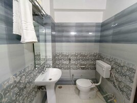 Um banheiro com pia, vaso sanitário e chuveiro.