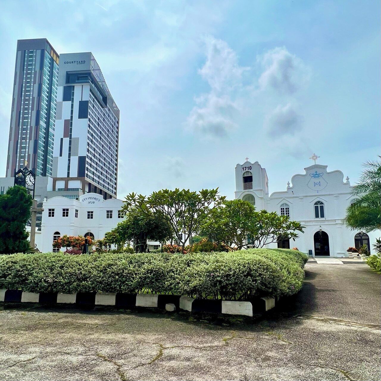 Um edifício histórico com uma torre do relógio e um arranha-céu moderno ao fundo.