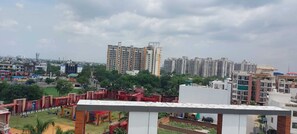 Zona residencial com edifícios altos, um parquinho e um campo esportivo.