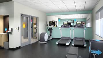 Centro de fitness com esteiras, bicicleta ergométrica e aparelho de musculação.