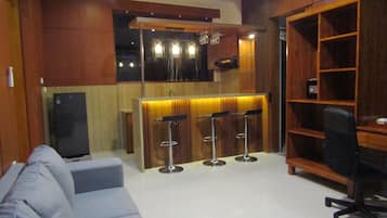 Suíte superior, 1 cama King, sacada, vista para a piscina | Área de estar | TV LED 50 polegadas com canais digitais, impressoras