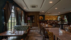 Um restaurante com piso de madeira, assentos de couro e um bar com prateleiras de garrafas.