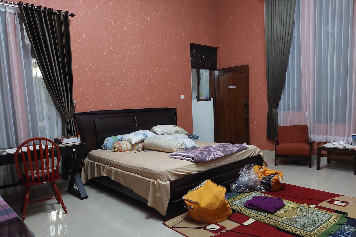 Quarto com uma cama, uma escrivaninha e uma cadeira.