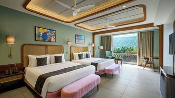 Quarto de hotel com duas camas, varanda e vista, e uma televisão.