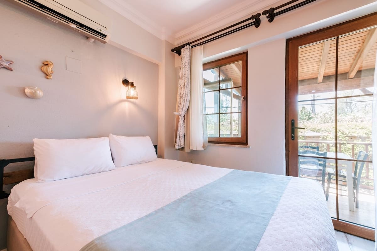 Quarto com cama, janela e vista para o exterior.