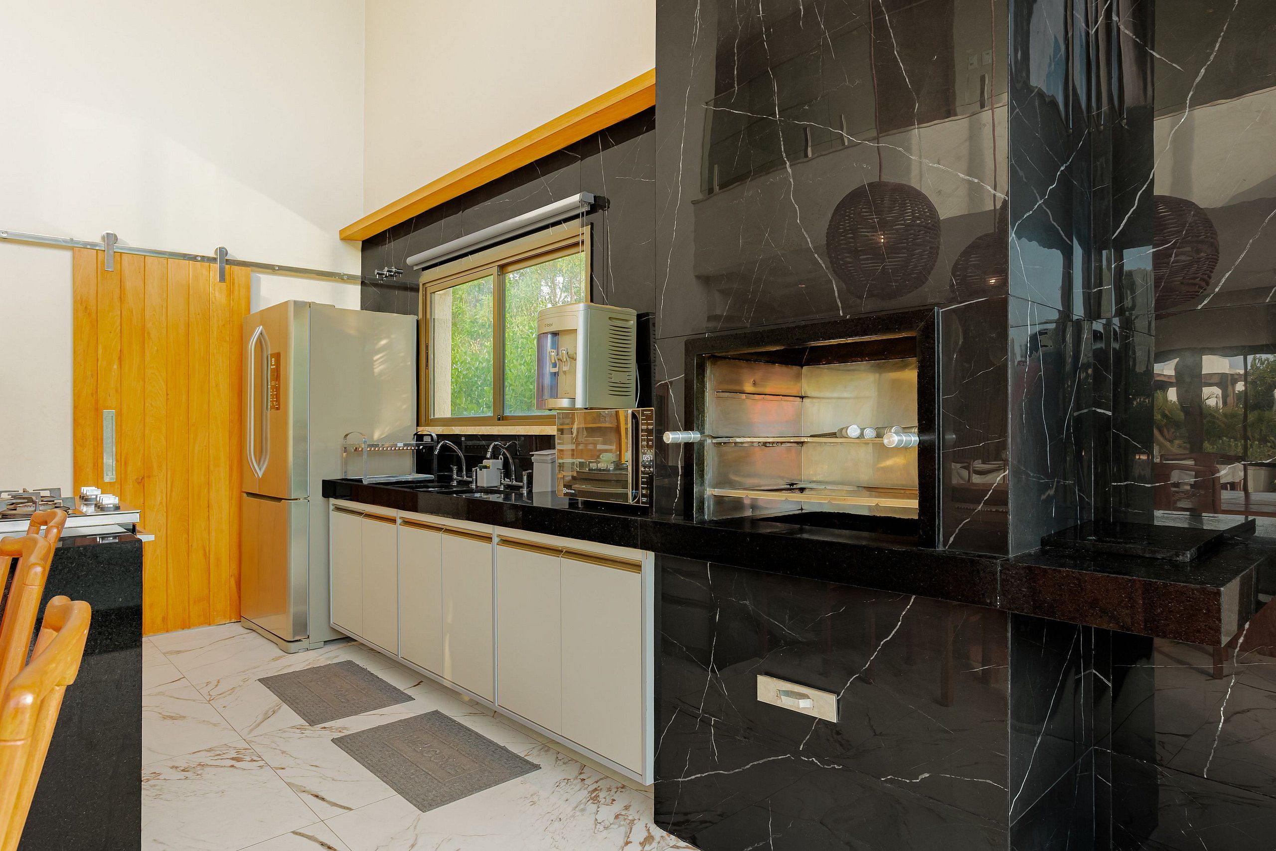 Cozinha moderna com geladeira, pia e forno embutido.