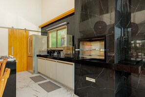 Cozinha moderna com geladeira, pia e forno embutido.