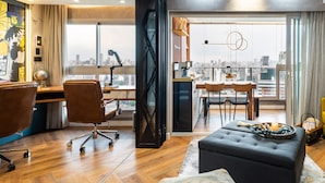 Sala de estar moderna com vista para a cidade, área de refeições e espaço de trabalho.