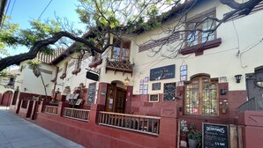 Um edifício com uma placa indicando "Conchita Fores cafe" e outra placa com a inscrição "Desayunos".