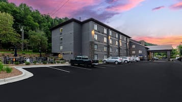 Um hotel de vários andares com design moderno, que inclui estacionamento e área de estar ao ar livre.