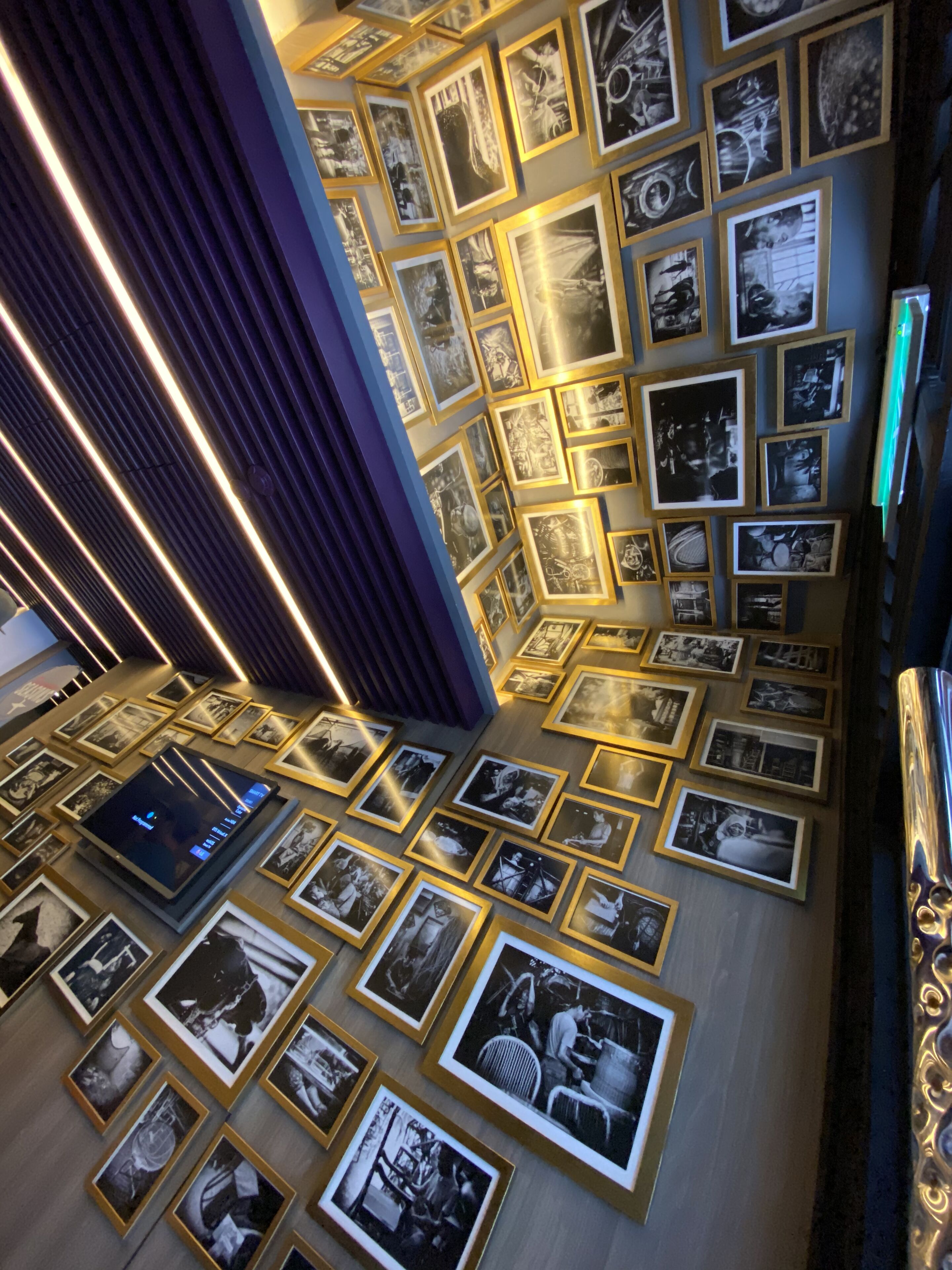 Uma galeria com fotografias emolduradas nas paredes.