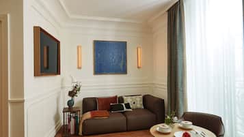 Uma sala de estar moderna com um sofá marrom, uma mesa de centro e um espaço de jantar com uma cadeira e pratos de comida.