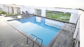 Piscina no terraço com vista desobstruída para os edifícios e áreas verdes ao redor.