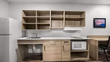 Um frigorífico/congelador grande, um micro-ondas, uma placa de cozinha