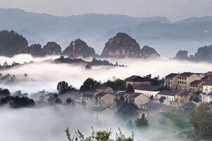 Um bairro residencial com casas envoltas em névoa e montanhas.