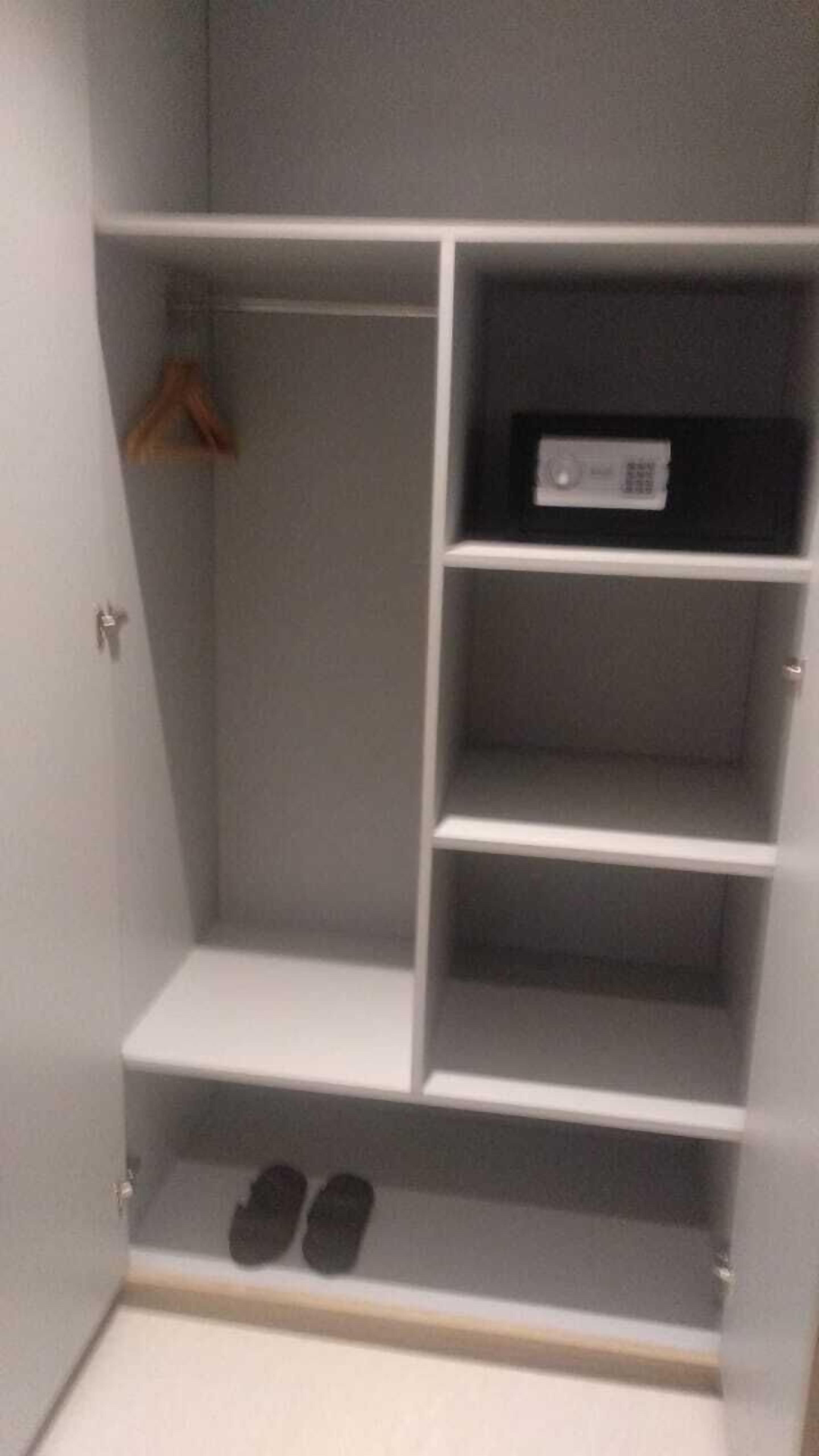 Armário com várias prateleiras e um sapateiro.