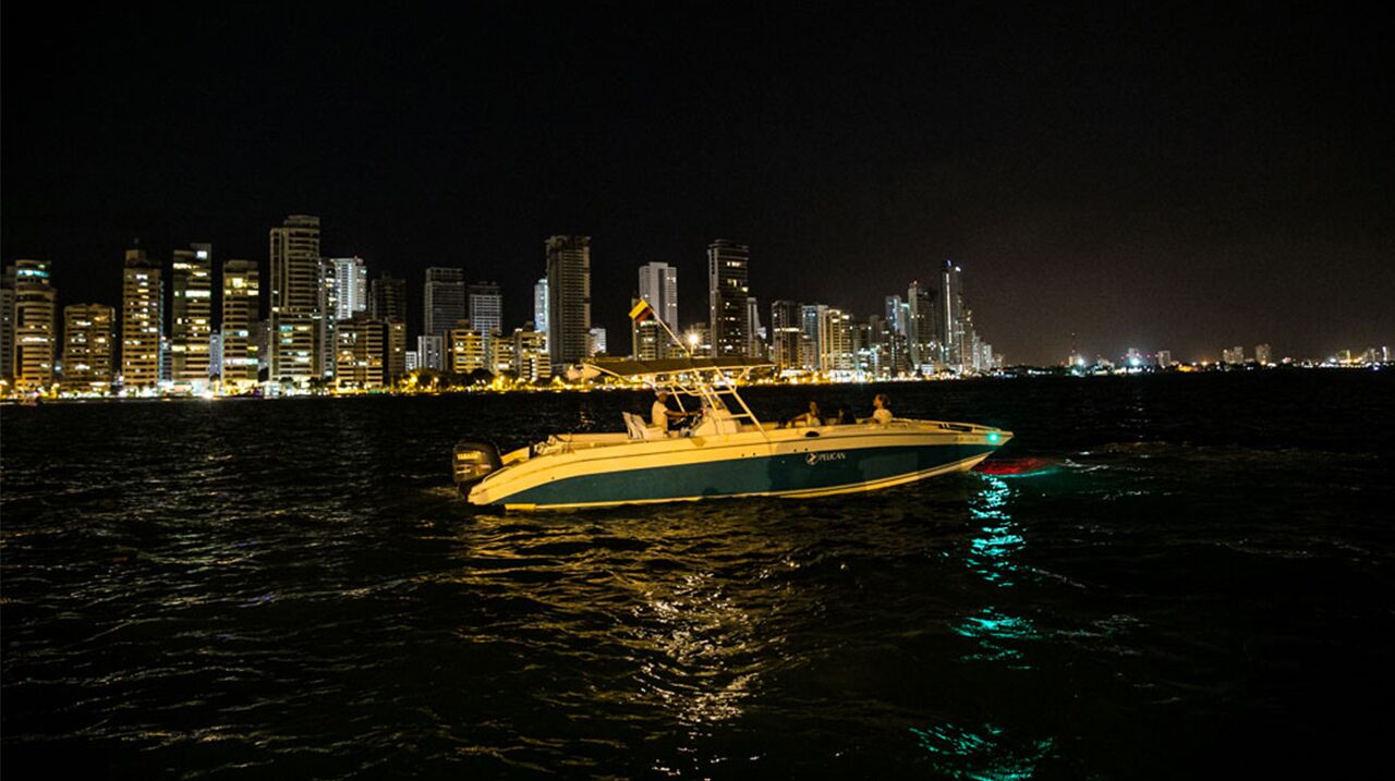 Um barco com o horizonte urbano ao fundo.